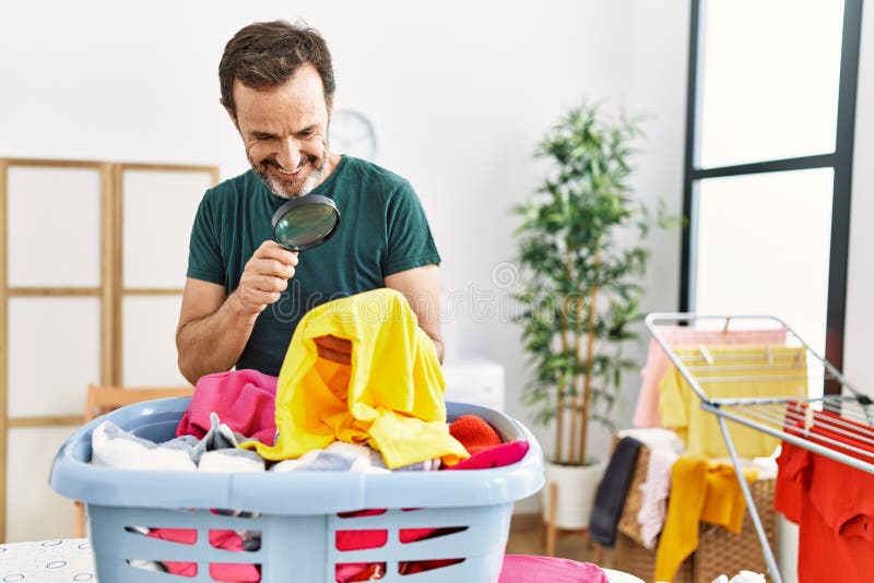 Middle Age Hispanic Man Doing Laundry Looking for Stain on Clothes ...