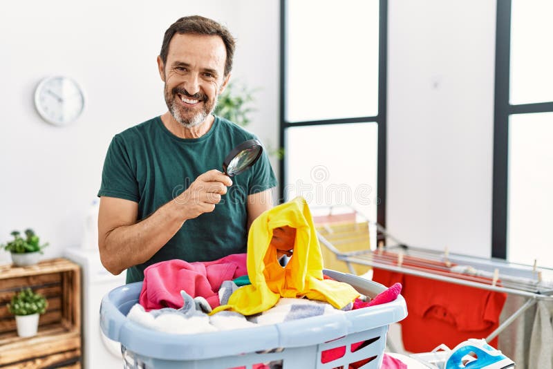 Middle Age Hispanic Man Doing Laundry Looking for Stain on Clothes ...