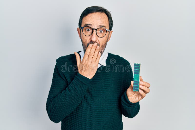 Middle Age Hispanic Man Holding Memory Ram Covering Mouth with Hand ...