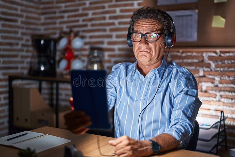 Middle Age Hispanic Man Using Touchpad Sitting on the Table at Night ...