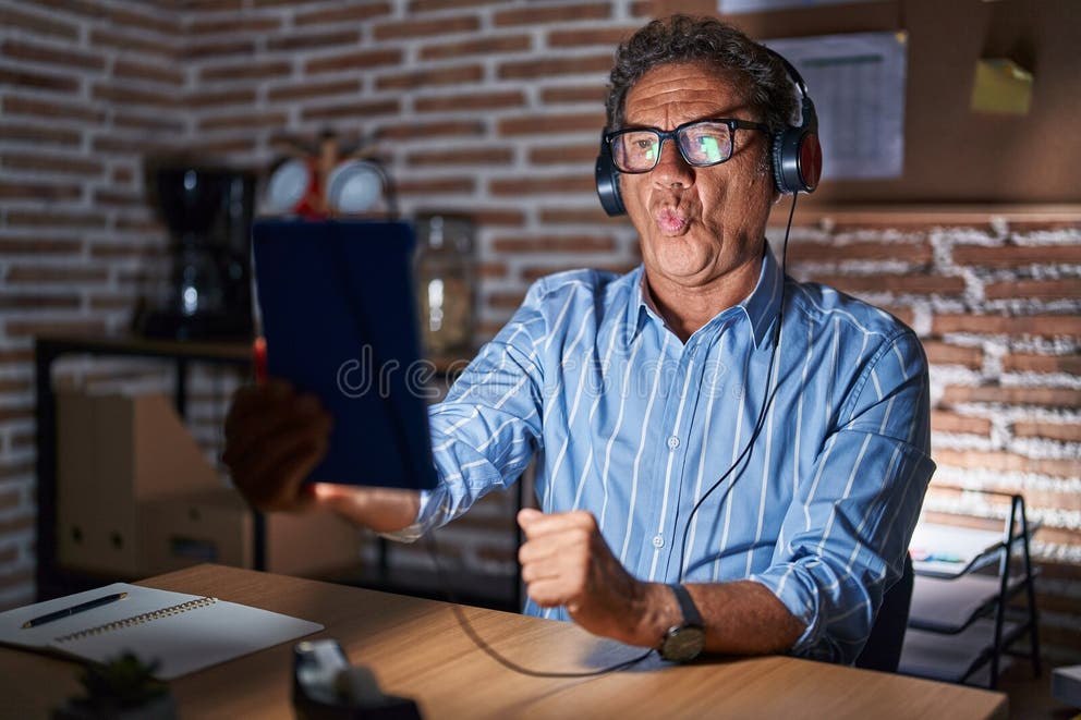 Middle Age Hispanic Man Using Touchpad Sitting on the Table at Night ...