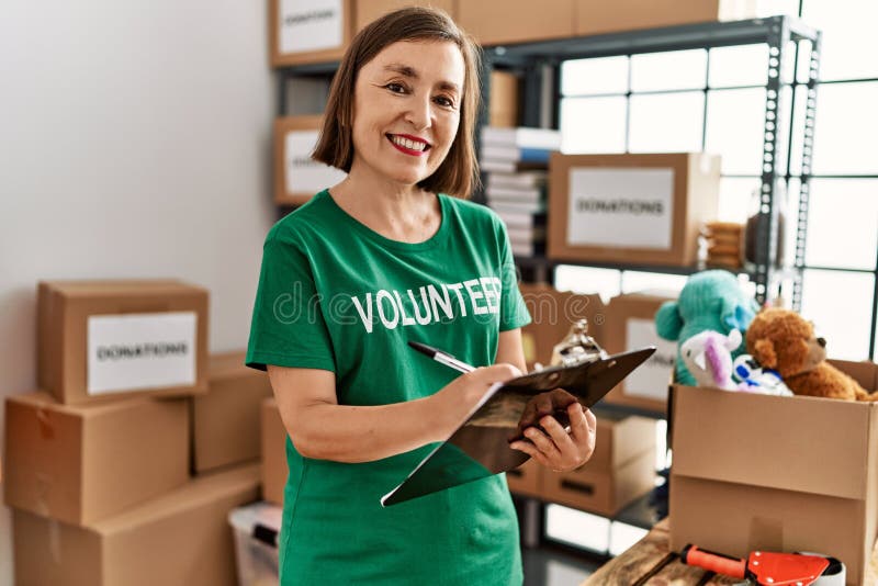Middle Age Hispanic Woman Checking Donations on Checklist at Donations ...