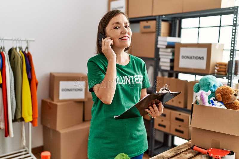 Middle Age Hispanic Woman Checking Donations Speaking on the Phone at ...