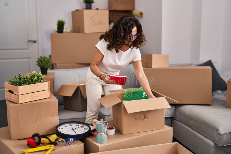 Middle Age Hispanic Woman Packing Boxes at New Home Stock Photo - Image ...