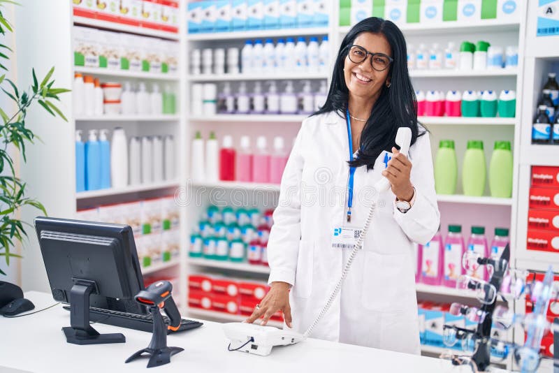 Middle Age Hispanic Woman Pharmacist Talking on Telephone Using ...
