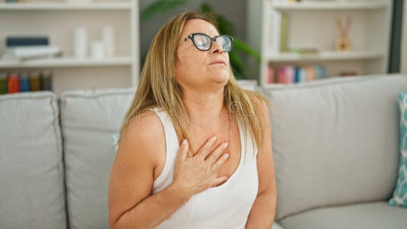 Middle Age Hispanic Woman Sitting on Sofa Suffering Heart Attack at ...