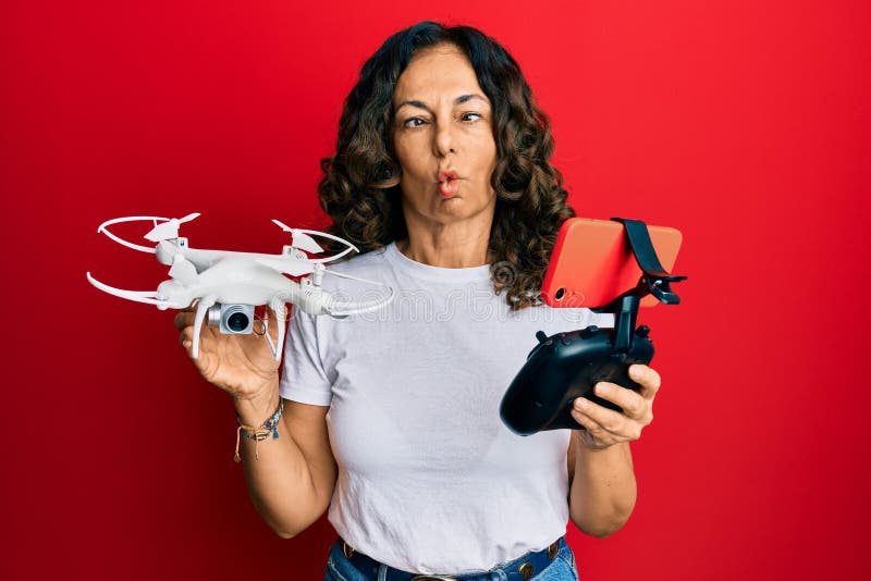 Middle Age Hispanic Woman Using Drone Making Fish Face with Mouth and ...