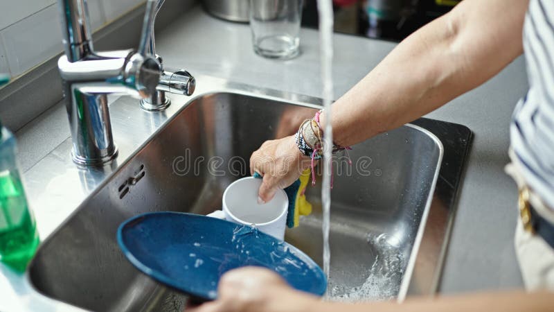 Middle Age Hispanic Woman Washing Plates at the Kitchen Stock Photo ...