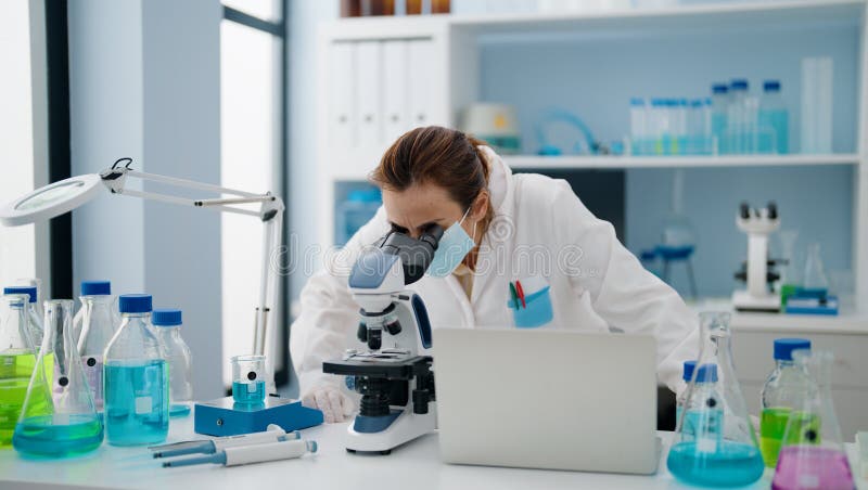 Middle Age Hispanic Woman Wearing Scientist Uniform and Medical Mask ...