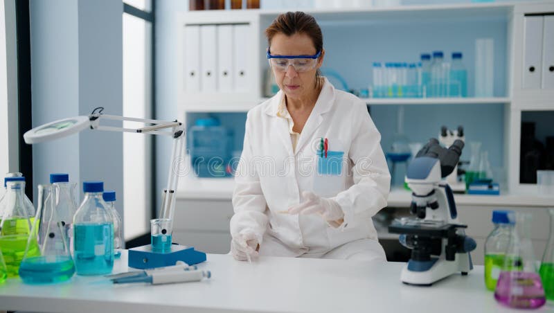 Middle Age Hispanic Woman Wearing Scientist Uniform Working at ...