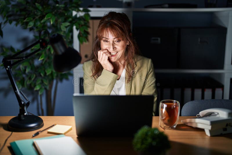Middle Age Hispanic Woman Working Using Computer Laptop at Night ...