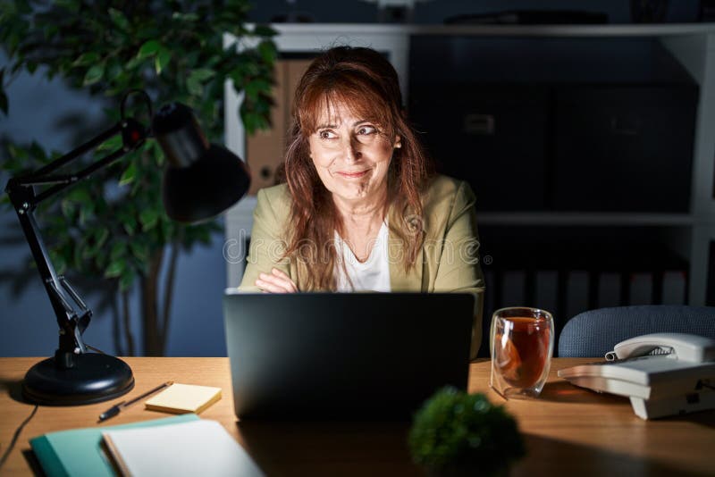 Middle Age Hispanic Woman Working Using Computer Laptop at Night ...