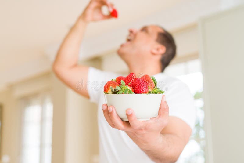 Middle Age Man Eating Strawberry at Home Stock Image - Image of healthy ...