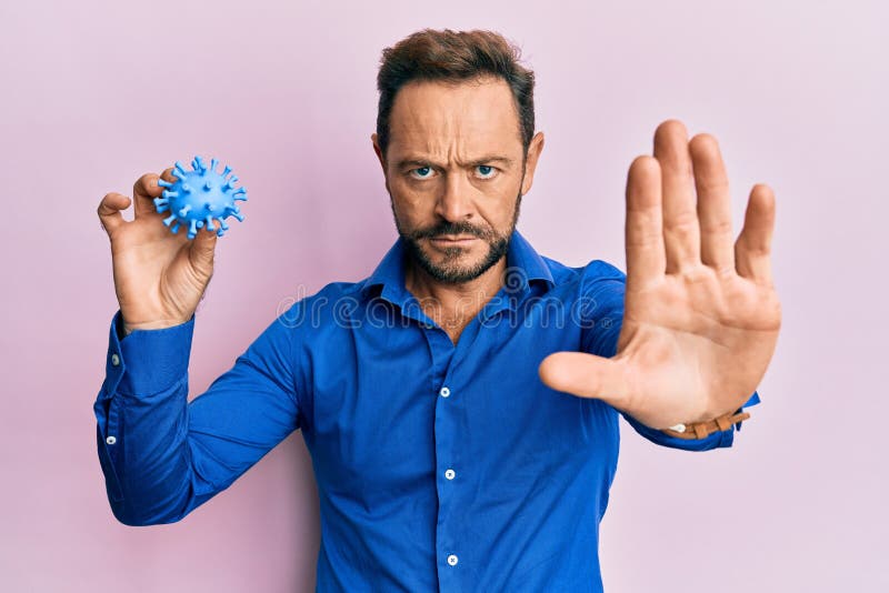 Middle Age Man Holding Virus Toy with Open Hand Doing Stop Sign with ...