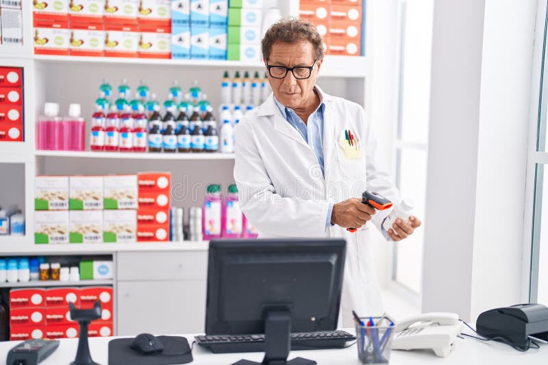 Middle Age Man Pharmacist Scanning Pills Bottle at Pharmacy Stock Photo ...