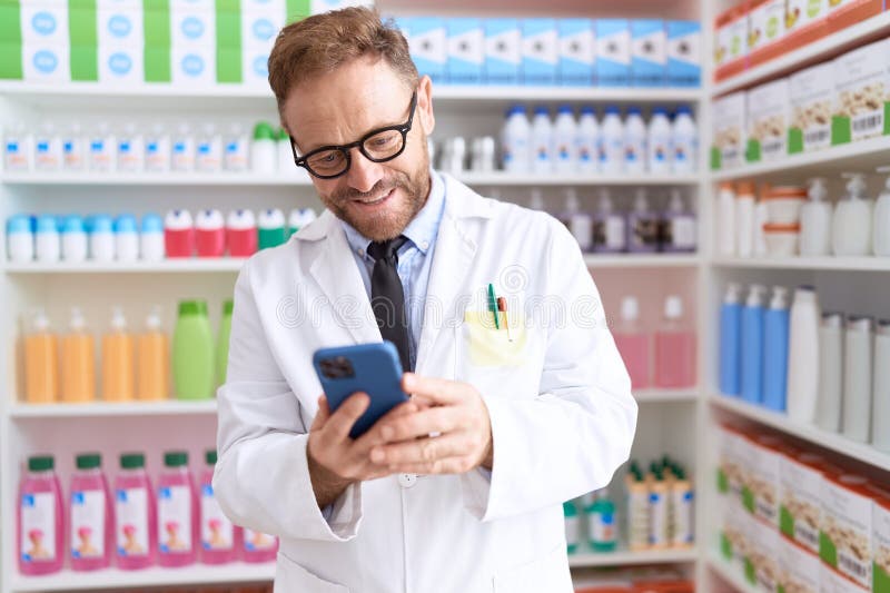 Middle Age Man Pharmacist Using Smartphone Working at Pharmacy Stock ...