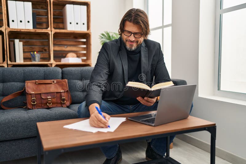 Middle Age Man Psychologist Reading Book Writing on Document at ...