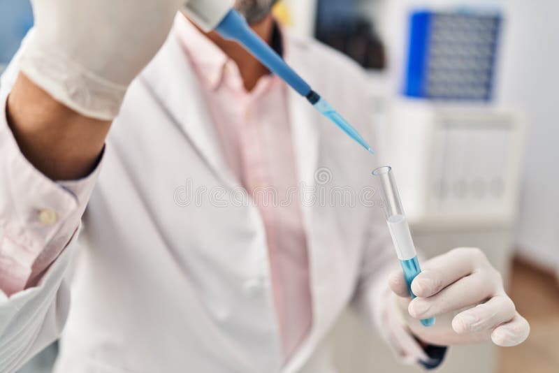 Middle Age Man Scientist Pouring Liquid on Test Tube at Laboratory ...