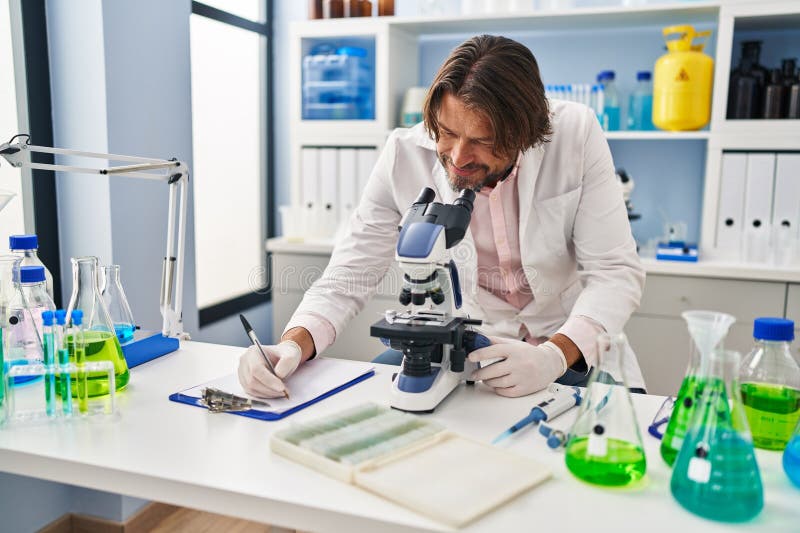Middle Age Man Scientist Using Microscope Writing on Document at ...