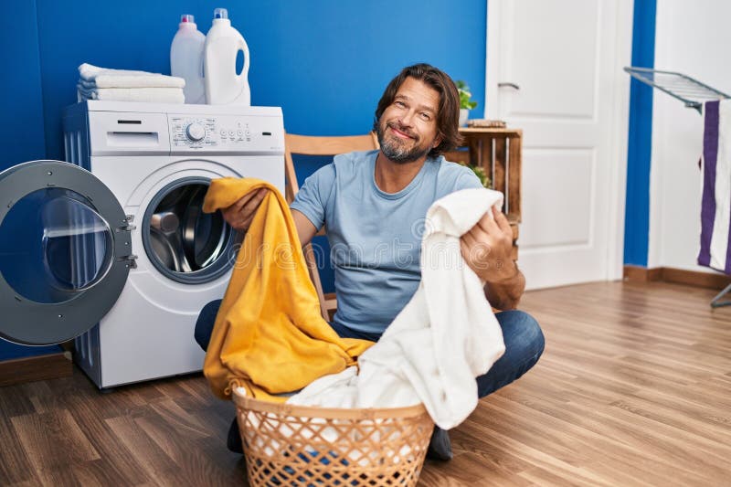 Middle Age Man Smiling Confident Washing Clothes at Laundry Room Stock ...