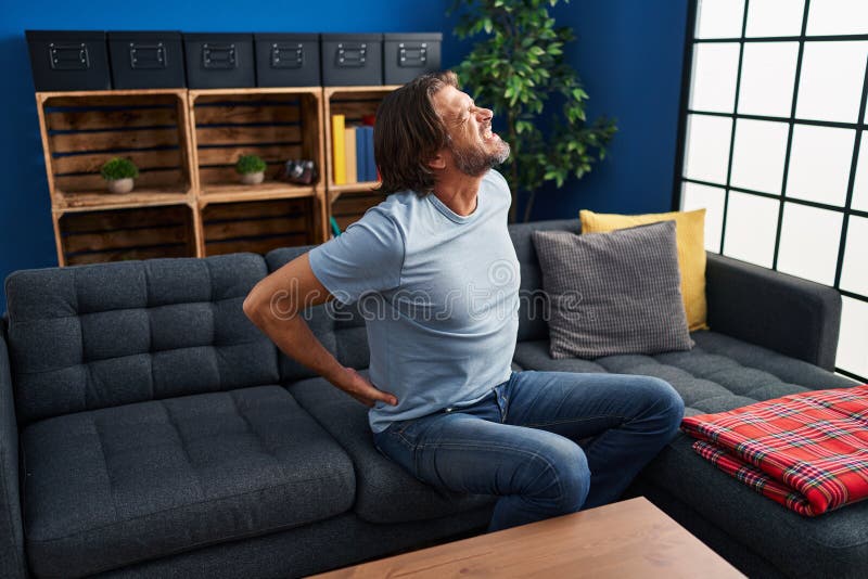 Middle Age Man Suffering for Backache Sitting on Sofa at Home Stock ...