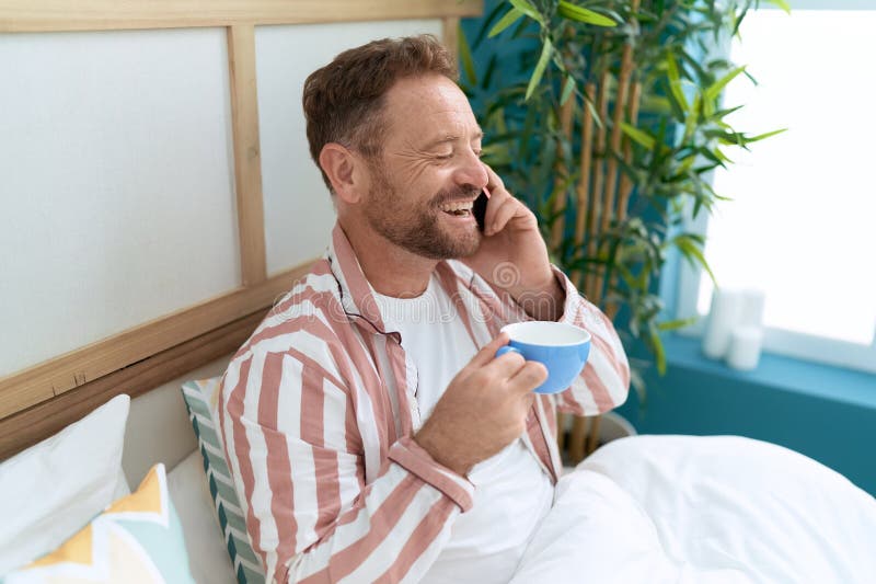 Middle Age Man Talking on Smartphone Drinking Coffee at Bedroom Stock ...