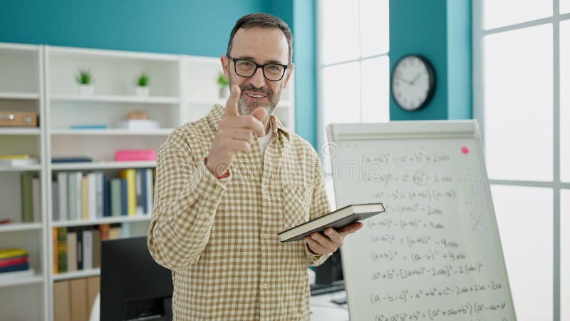 Middle Age Man Teacher Teaching Lesson Holding Book at Classroom Stock ...