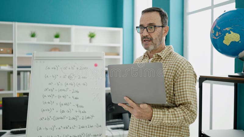 Middle Age Man Teacher Teaching Lesson Using Laptop at Classroom Stock ...