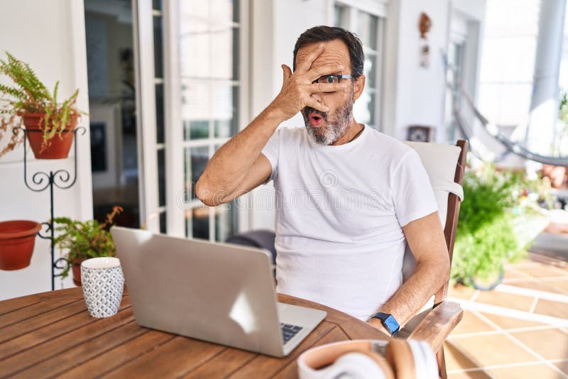 Middle Age Man Using Computer Laptop at Home Peeking in Shock Covering ...