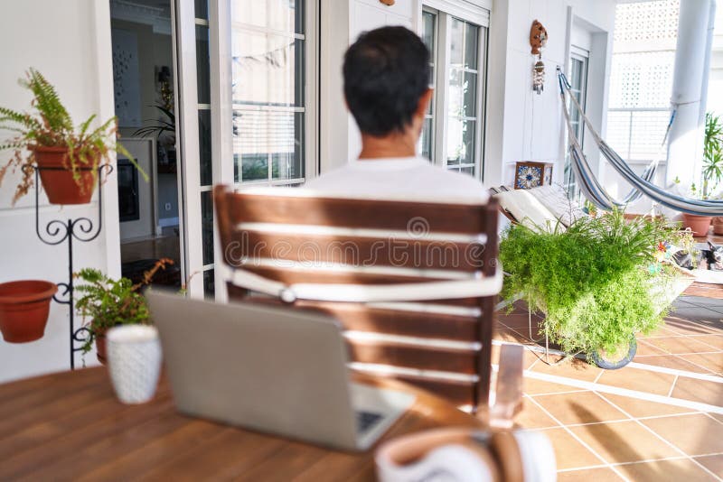 Middle Age Man Using Computer Laptop at Home Standing Backwards Looking ...