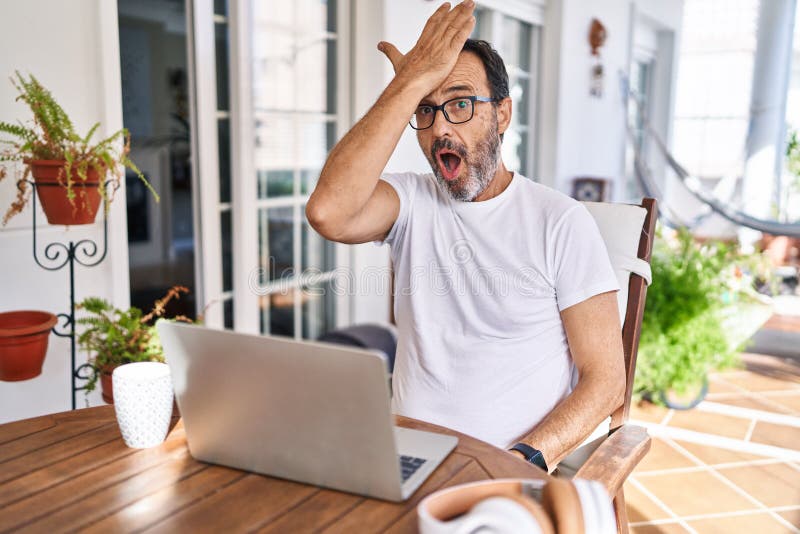 Middle Age Man Using Computer Laptop at Home Surprised with Hand on ...