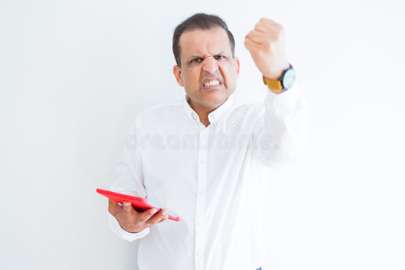 Middle Age Man Using Digital Table Over White Wall Annoyed and ...