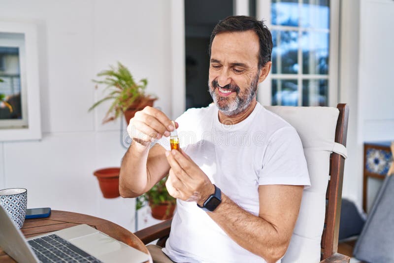Middle Age Man Using Laptop Drinking Medicine Syrup at Terrace Home ...