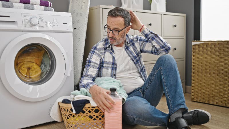 Middle Age Man Waiting for Washing Machine Sitting on Floor at Laundry ...