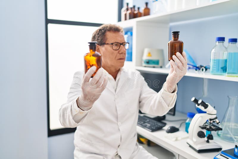 Middle Age Man Wearing Scientist Uniform Looking Bottles at Laboratory ...
