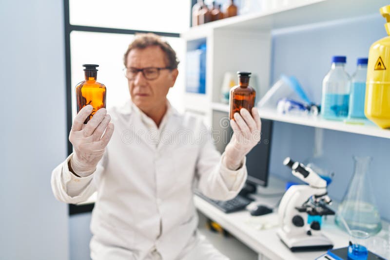 Middle Age Man Wearing Scientist Uniform Looking Bottles at Laboratory ...