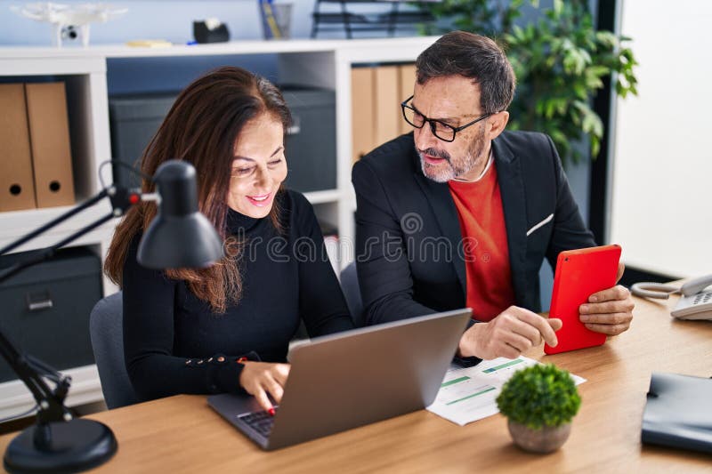 Middle Age Man and Woman Business Workers Using Touchpad and Laptop ...