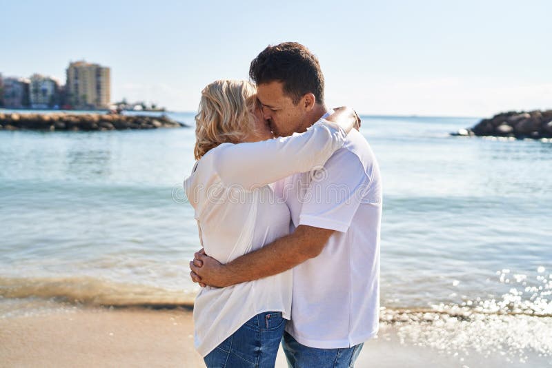Middle Age Man And Woman Couple Hugging Each Other And Kissing Standing