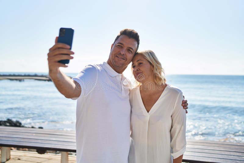 Middle Age Man And Woman Couple Hugging Each Other Make Selfie By The