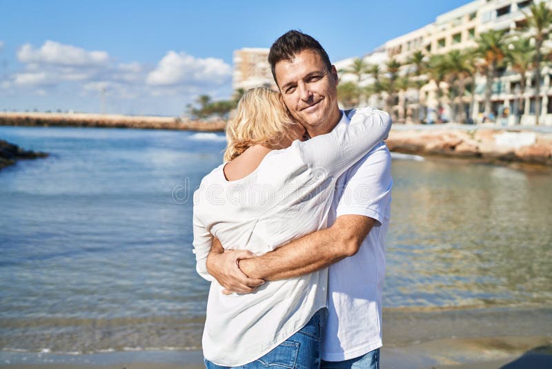 Middle Age Man And Woman Couple Hugging Each Other Standing At Seaside