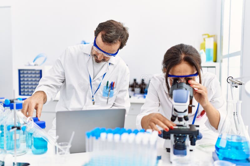 Middle Age Man and Woman Partners Wearing Scientist Uniform Using ...
