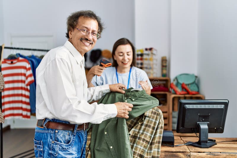 Middle Age Man and Woman Smiling Confident Scanning Clothes Using ...