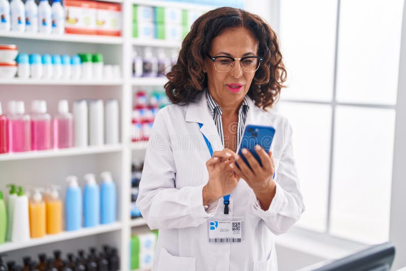 Middle Age Woman Pharmacist Using Smartphone Working at Pharmacy Stock ...