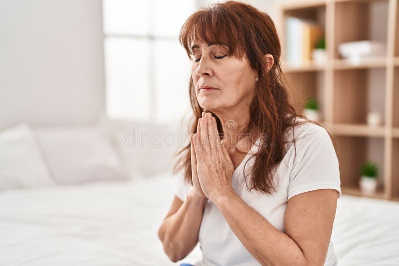 Middle Age Woman Praying Sitting on Bed at Bedroom Stock Photo - Image ...