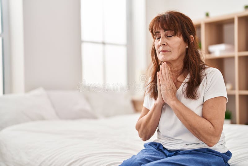 Middle Age Woman Praying Sitting on Bed at Bedroom Stock Photo - Image ...
