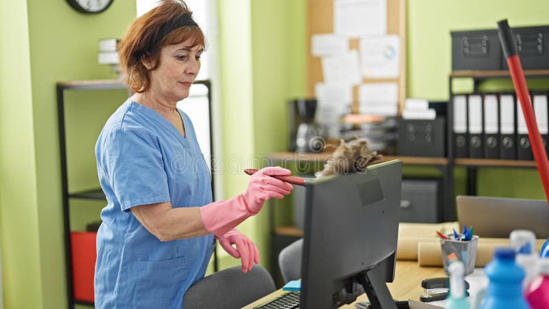 Middle Age Woman Professional Cleaner Cleaning Computer Using Duster at ...