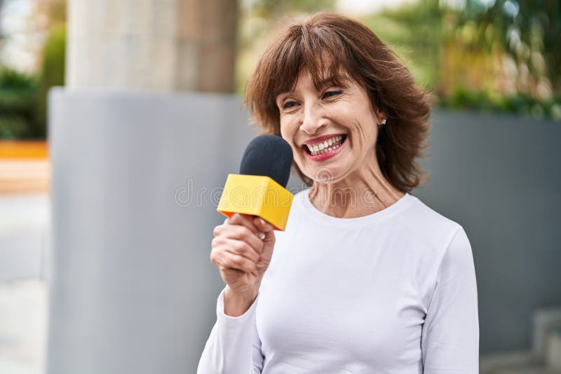 Middle Age Woman Reporter Working Using Microphone at Street Stock ...
