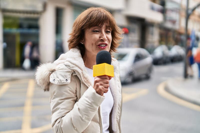 Middle Age Woman Reporter Working Using Microphone at Street Stock ...