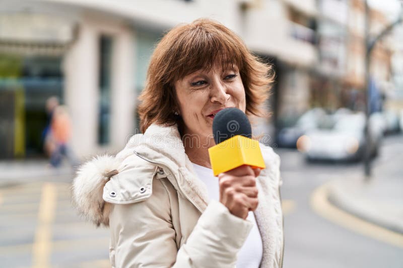Middle Age Woman Reporter Working Using Microphone at Street Stock ...