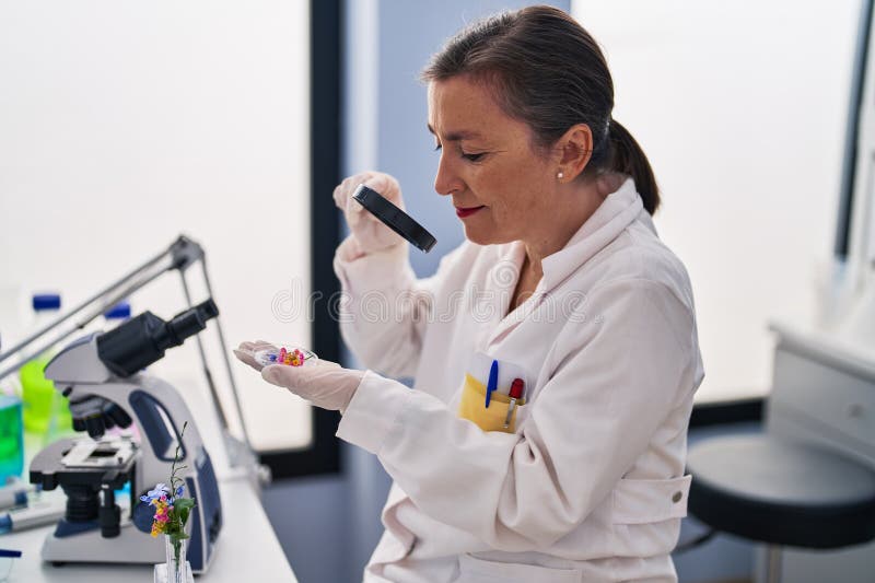 Middle Age Woman Scientist Looking Flowers Using Magnifying Glass at ...